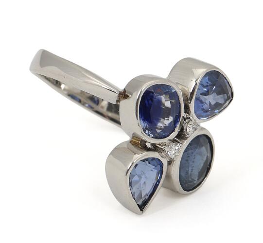 A sapphire and diamond ring set with four sapphires and two diamonds ...