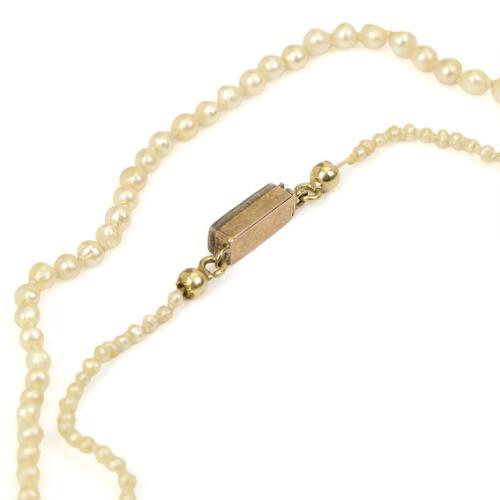 A pearl necklace set with numerous natural pearls and a diamond clasp ...