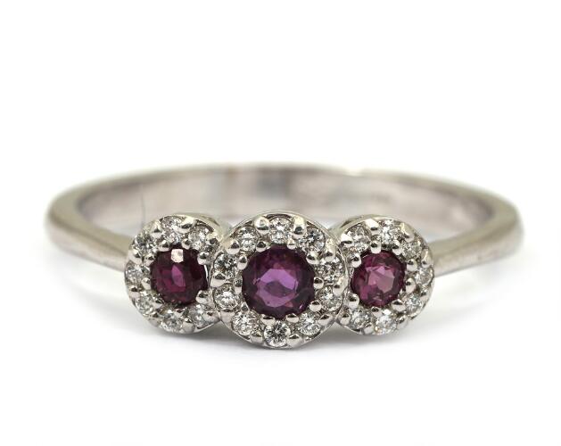 A ruby- and diamond ring set with three rubies encircled by numerous ...