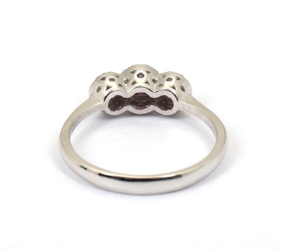 A ruby- and diamond ring set with three rubies encircled by numerous ...